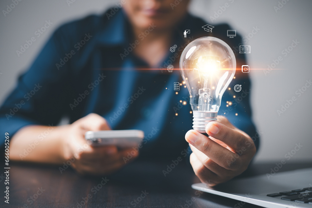 Hand holding light bulb showing graduation cap internet education ...