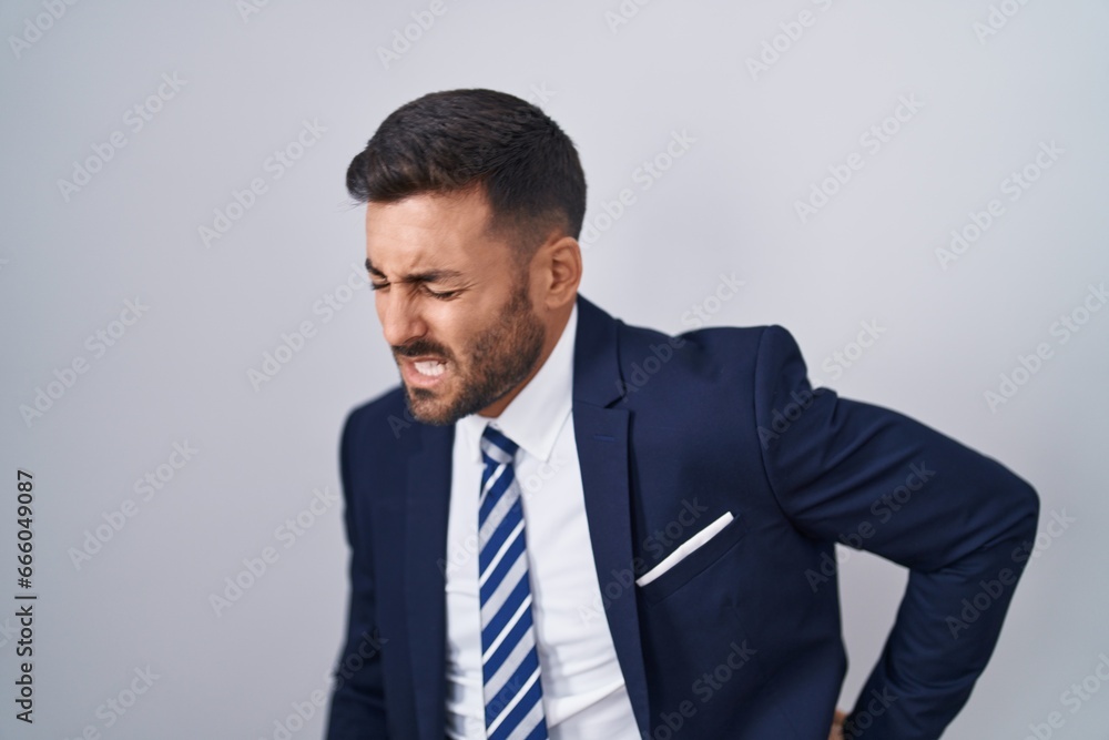 Handsome hispanic man wearing suit and tie suffering of backache ...