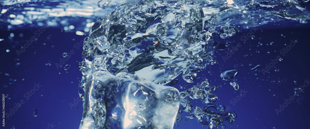 Water splashing and ice cube. Ice splashing into a glass of water ...