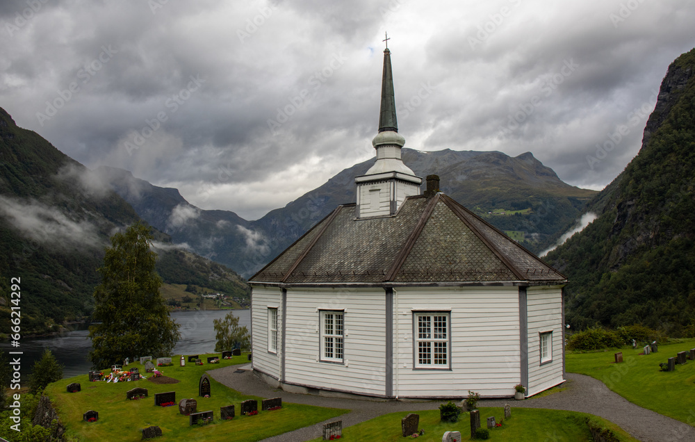 The beautiful octagonal Geiranger church next to the cemetery. It is ...