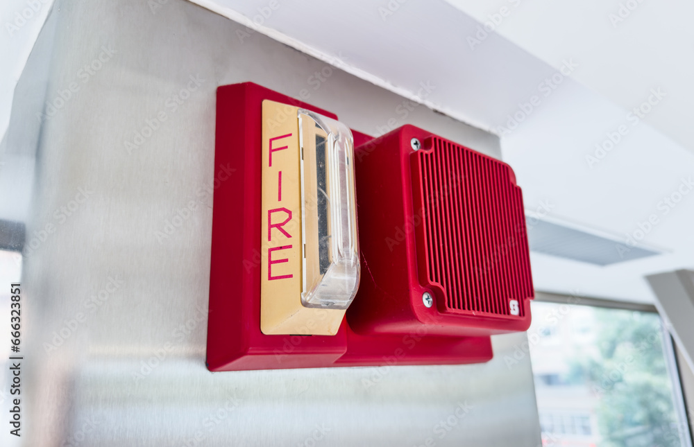 red, wall-mounted fire alarm with a glowing indicator, ready to alert ...
