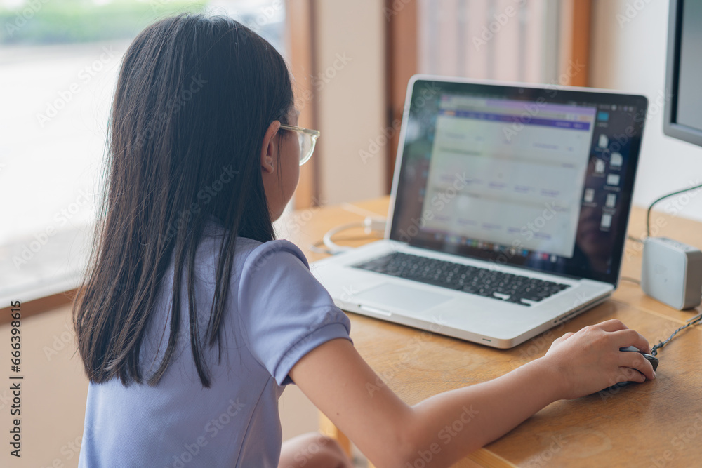 Portrait of little girl using laptop, student typing on keyboard ...