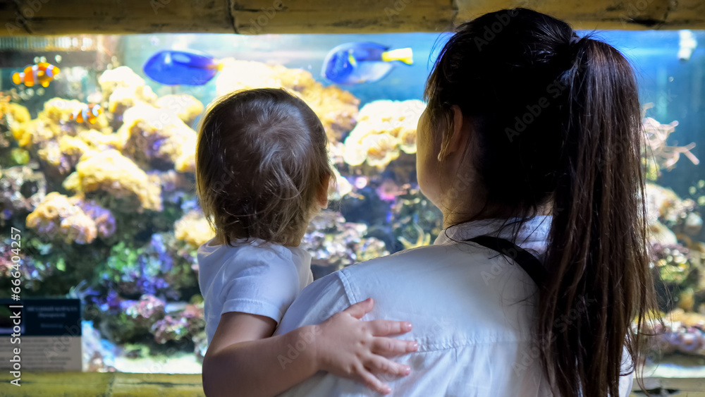 Young mother holds little girl in arms while standing in front of ...