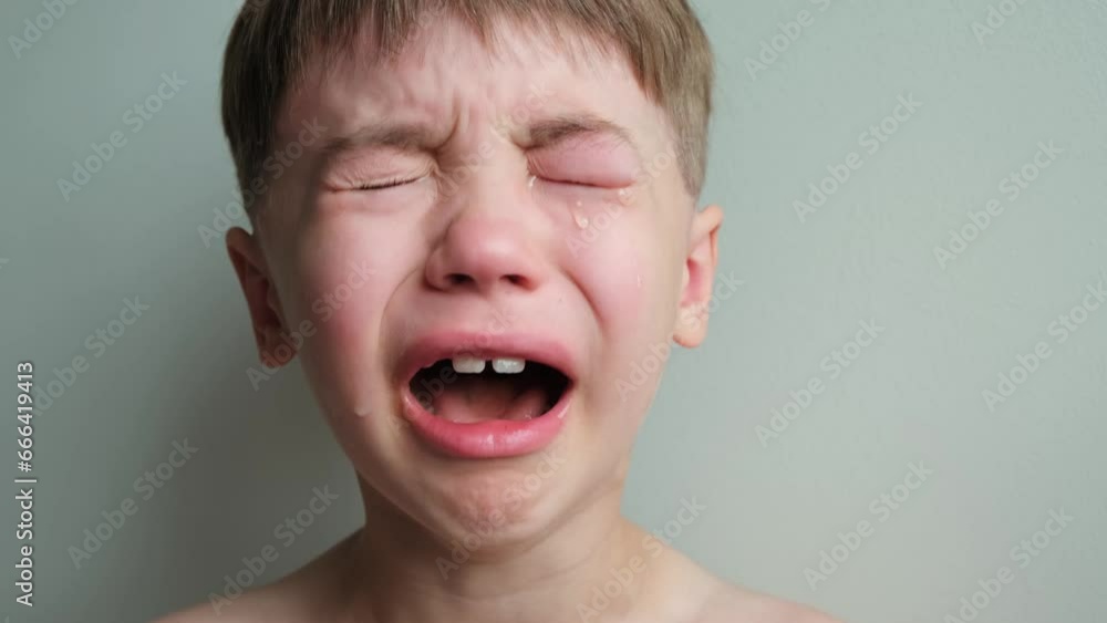 Dramatic portrait of a crying 7 year old boy. Tears flow from the eyes ...