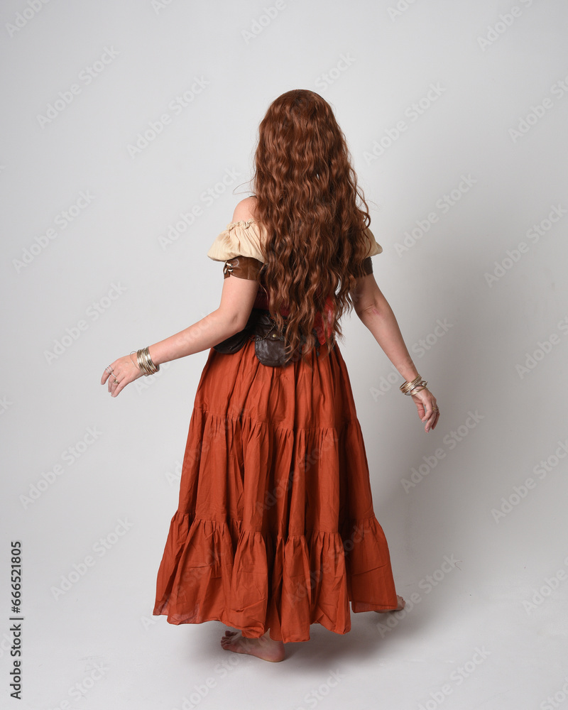 Full length portrait of beautiful red haired woman wearing a medieval ...