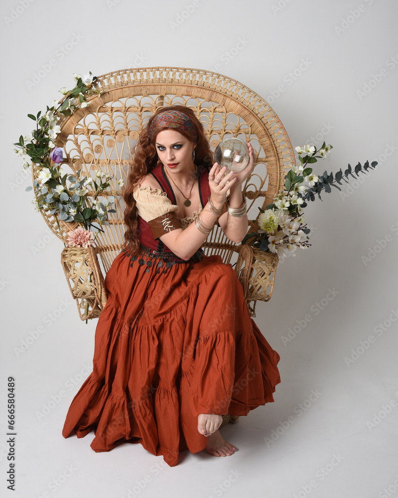 Full length portrait of beautiful red haired woman wearing a medieval maiden, fortune teller ...