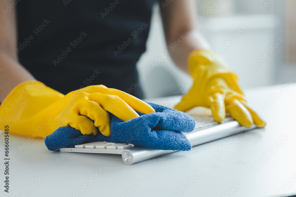 Cleaning staff wiping down office equipment, Wipe the keyboard clean ...