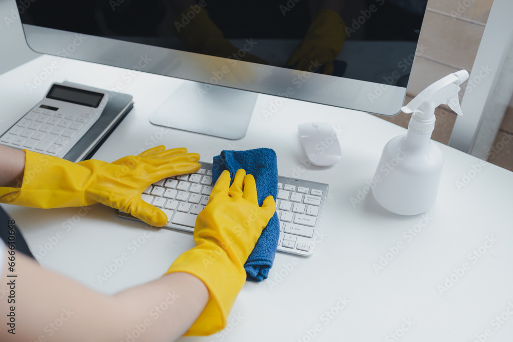 Cleaning staff wiping down office equipment, Wipe the keyboard clean ...