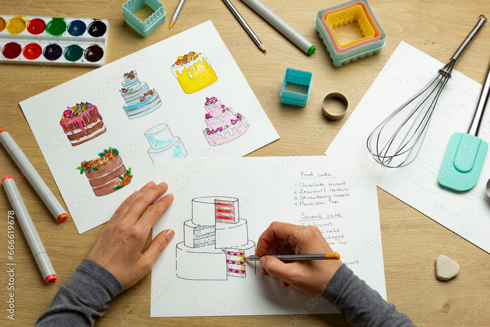 The pastry chef develops a cake design by drawing on paper. Creation of ...
