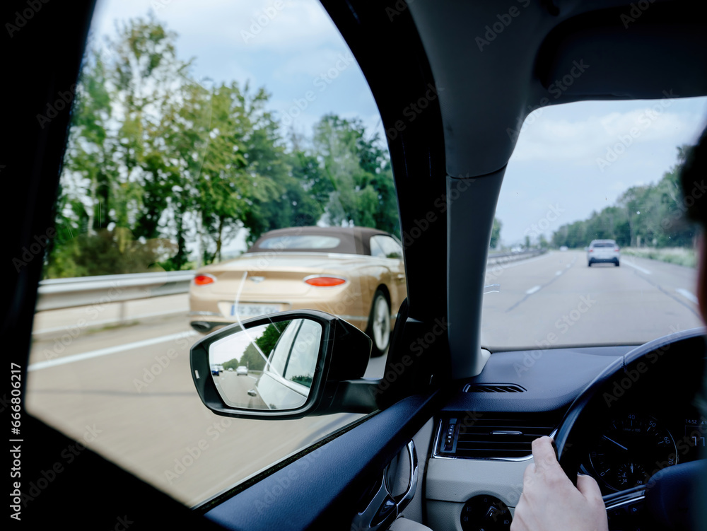 From the driver's POV, attention is directed towards the rearview ...