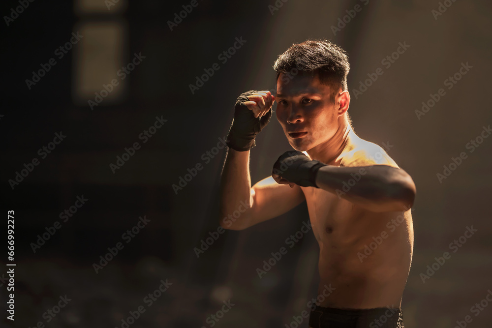 Young muay thai boxer man guarding up and training boxing in the dark ... Young muay thai boxer man guarding up and training boxing in the dark ...