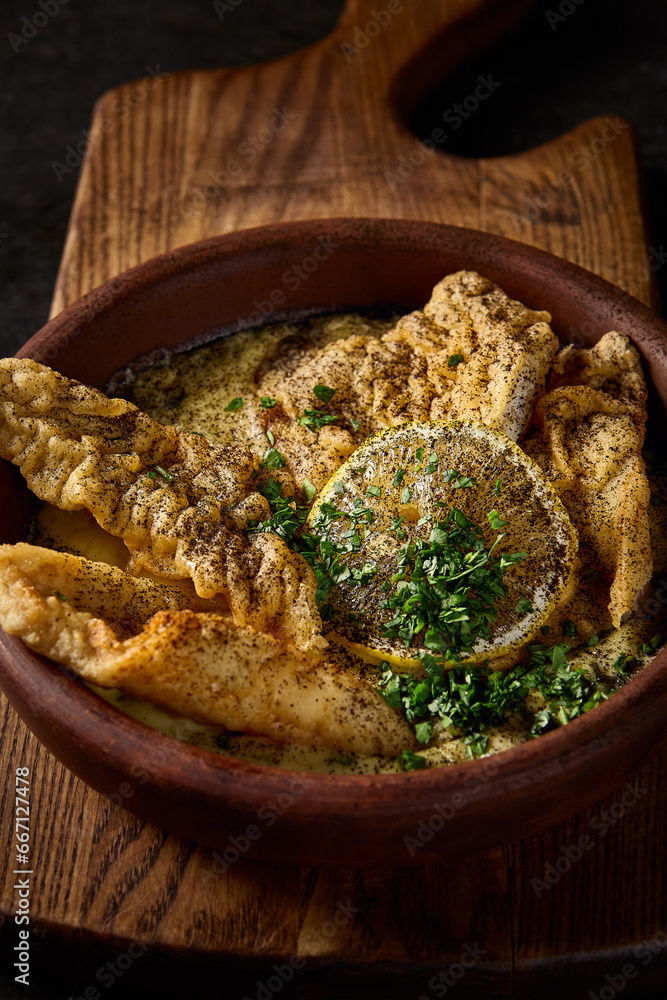 Close-up, vertical side view of the delectable kambala fish, fried to ...