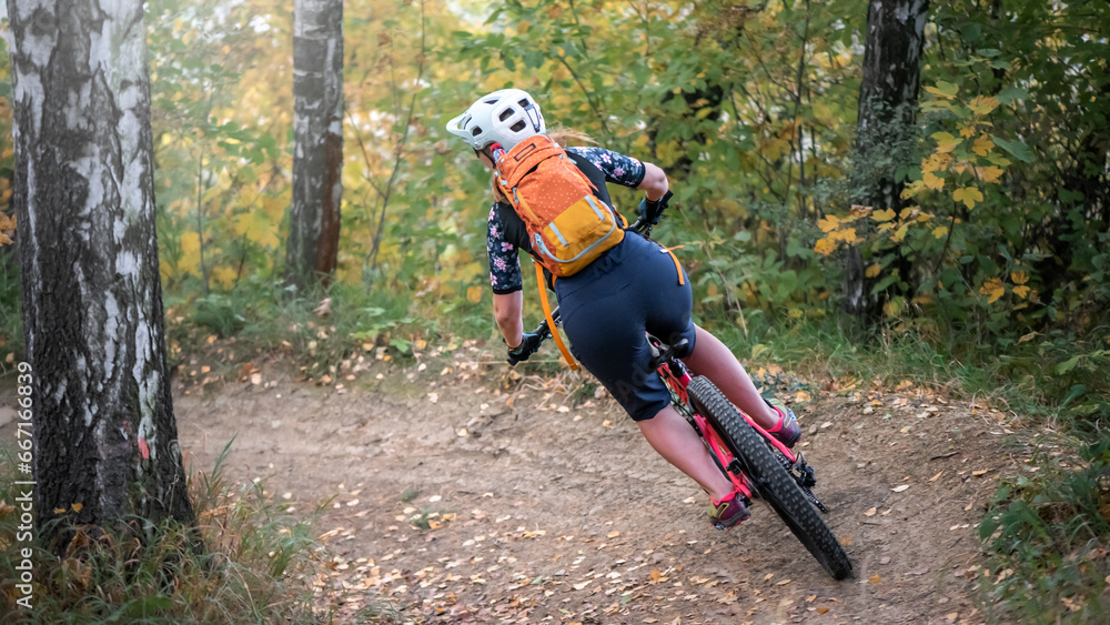 Bike downhill on single trails. A girl cyclist with his bike riding banked turn. foto de Stock ...