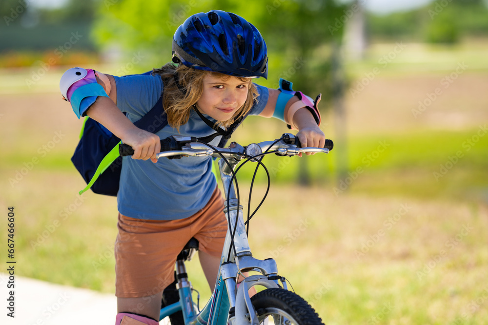 Boy in a helmet riding bike. Boy in safety helmet riding bike in city park. Child first bike ...
