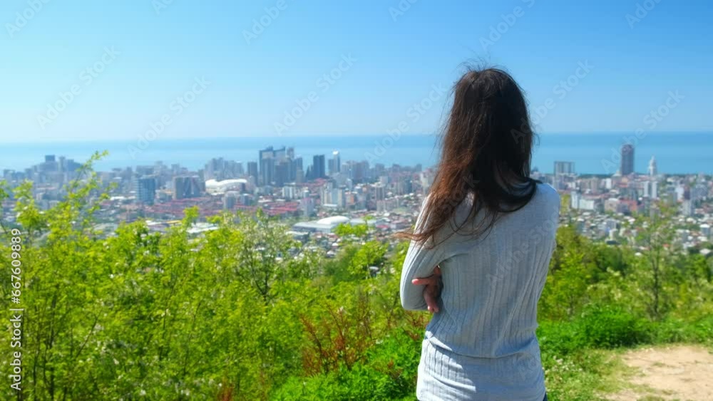 Woman tourisy admiring cityscape of Batumi city from mountain in sunny ...