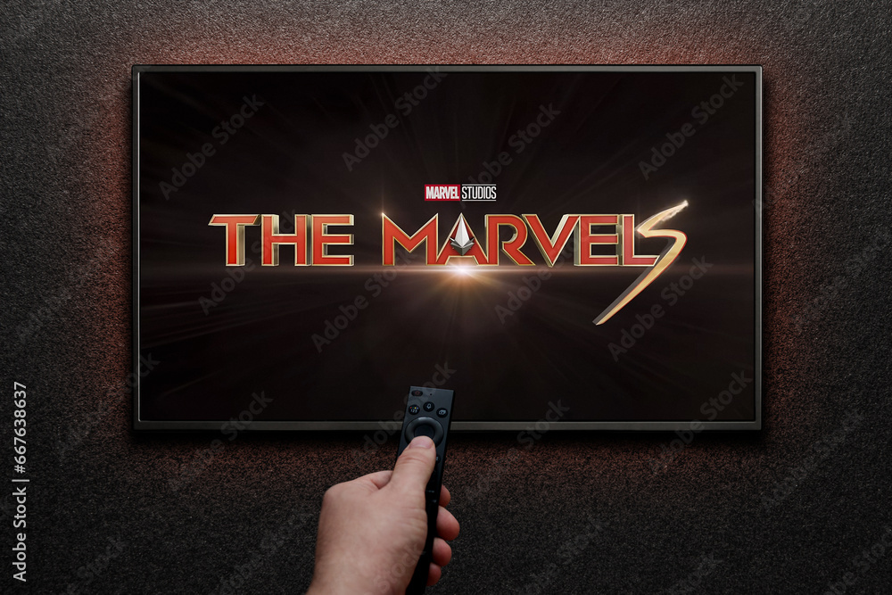 The Marvels trailer or movie on TV screen. Man turns on TV with remote ...