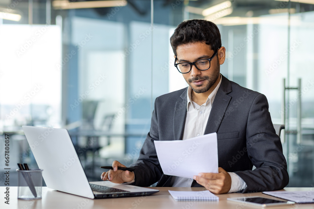 Portrait of serious pensive businessman behind paperwork, financier ...