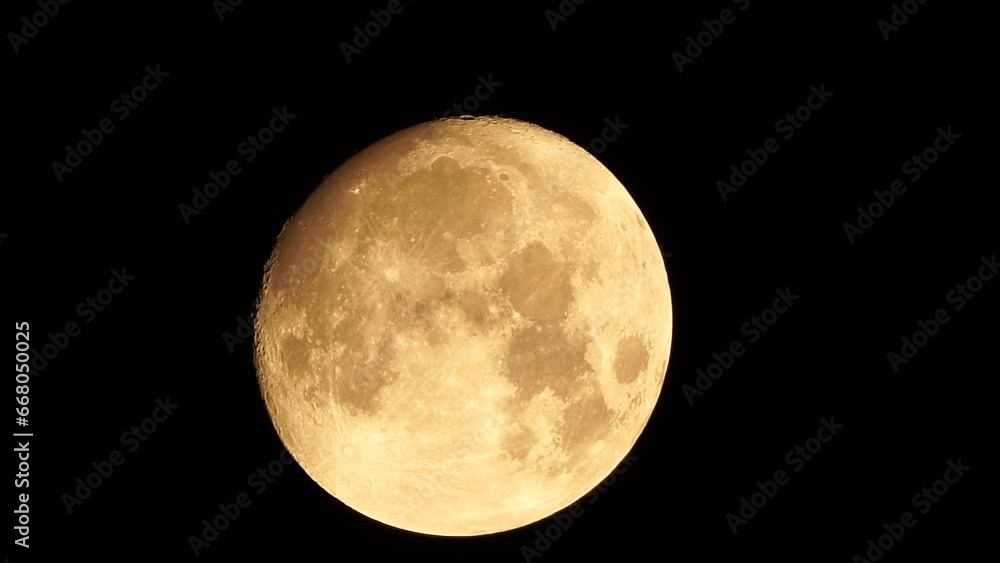 A glowing golden huge full moon seen from earth through the atmosphere ...