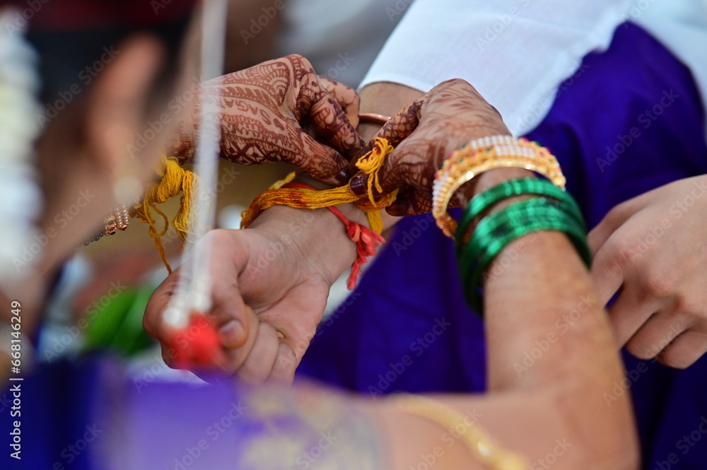 Ceremony of Wearing Turmeric Thread on hand of groom. Hands of bride ...