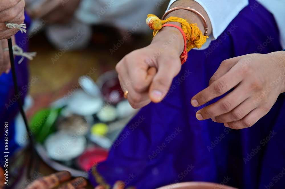 Turmeric Thread on hand of groom. Hands of bride and Groom in hindu ...