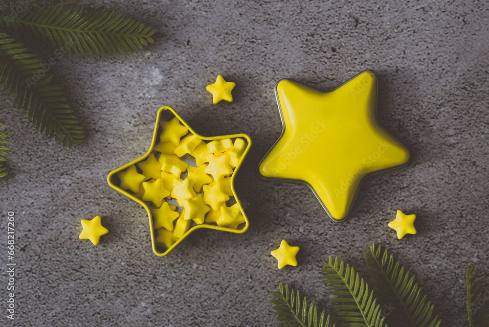 Overhead view of star shaped yellow candies in a star shaped metal box ...
