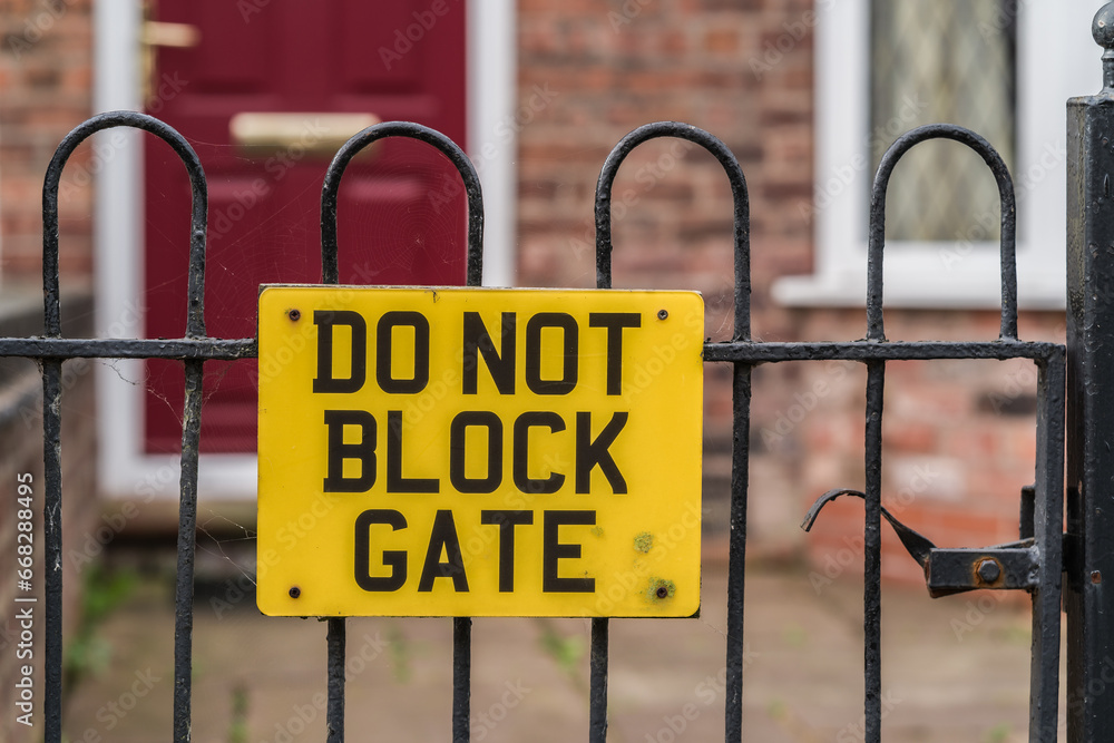 Yellow do not block gate sign with a house with a red door in the ...