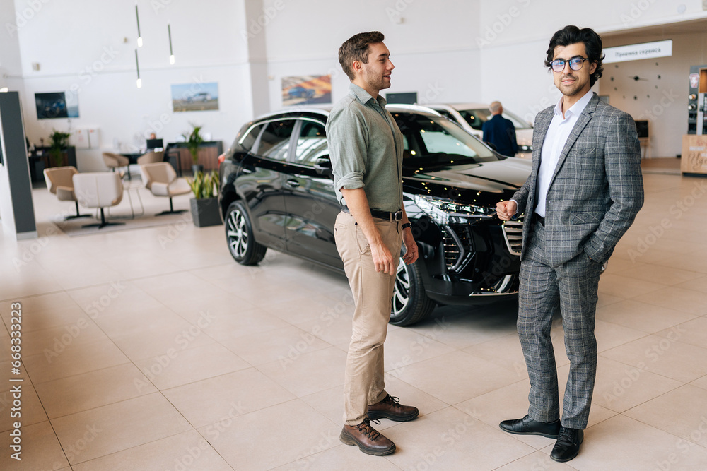 Full length portrait of professional male car seller with bearded male ...