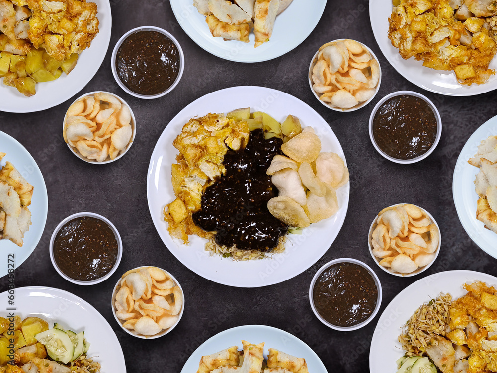 Plates of tahu tek telur with kerupuk or chips and petis sauce on a ...