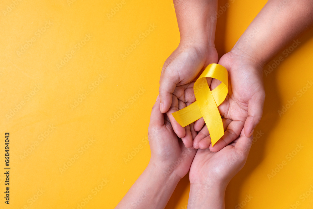 yellow ribbon on the hand of a cancer sick person, world cancer day ...