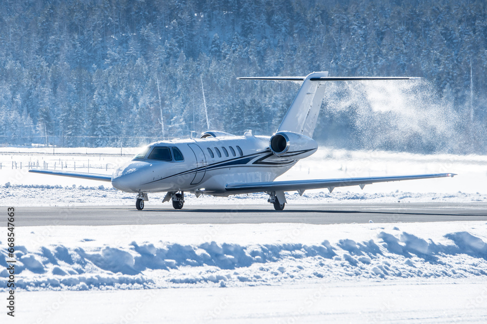 Luxury business jet taking off in engadin valley in the Swiss alps. The ...