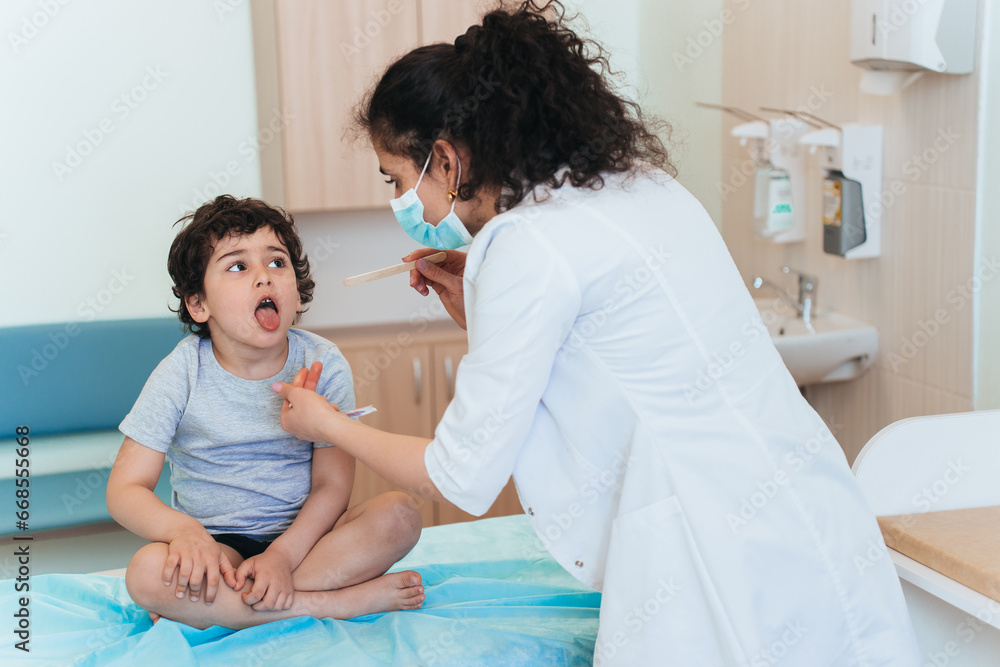 Female doctor examining little boy at medical office. Preschooler kid ...