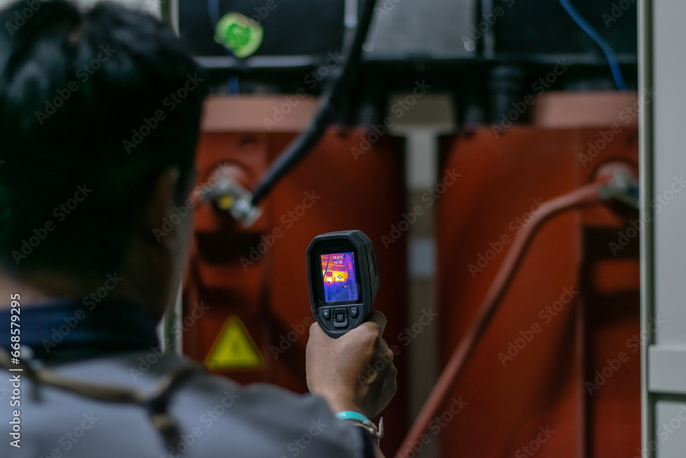 Professional Electrician use thermal infrared camera or thermometer ...