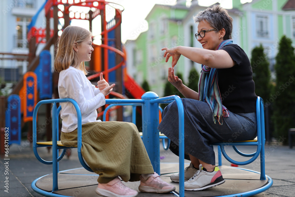 Two generations, a senior and a young woman, united by the joy of sign ...