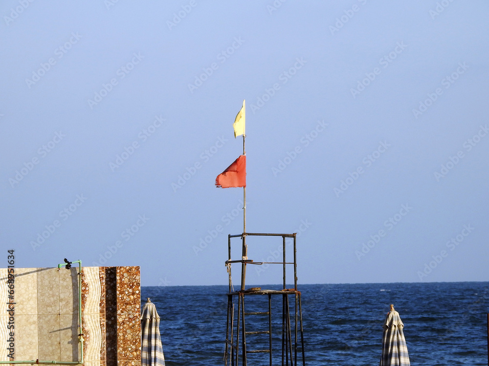 Yellow and red flags on the beach, beach warning flag system, red flag ...