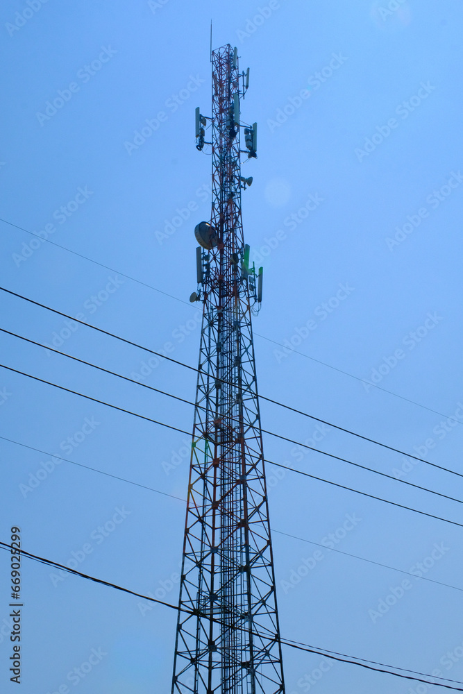 Industrial Photography. A towering radio signal tower against a bright blue sky background ...