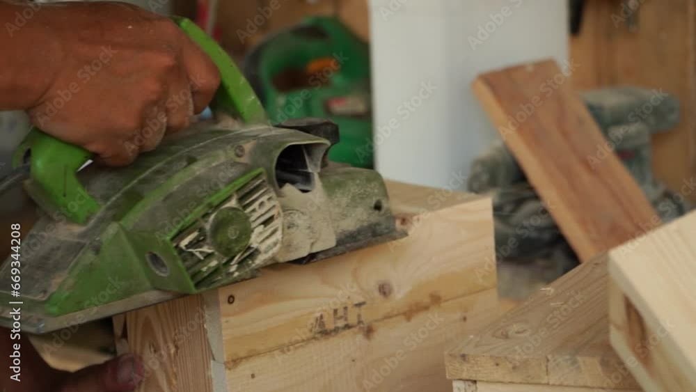 Close up of a carpenter working in a simple wood workshop. The workshop ...