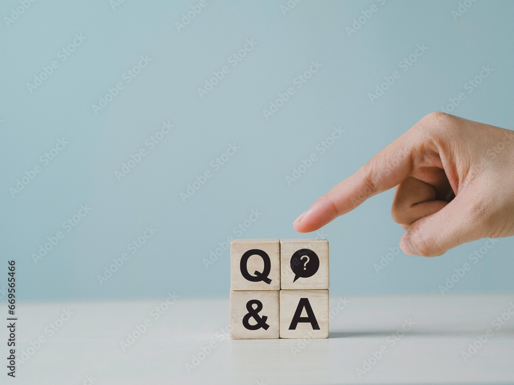 Question and answer concept. Q and A symbols on wooden blocks and hand ...