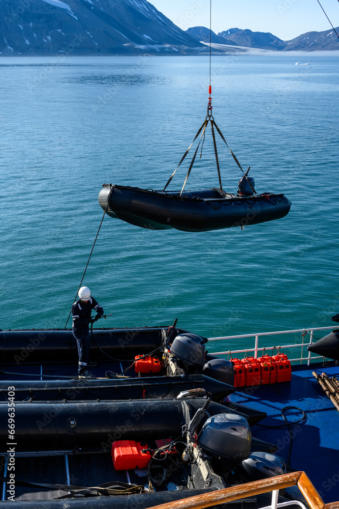 Rigid inflatable boat being offloaded from a cruise ship into the ...
