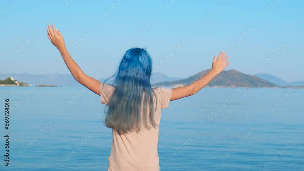 Spinning with open hands on beach. A view of stylish teen girl with ...