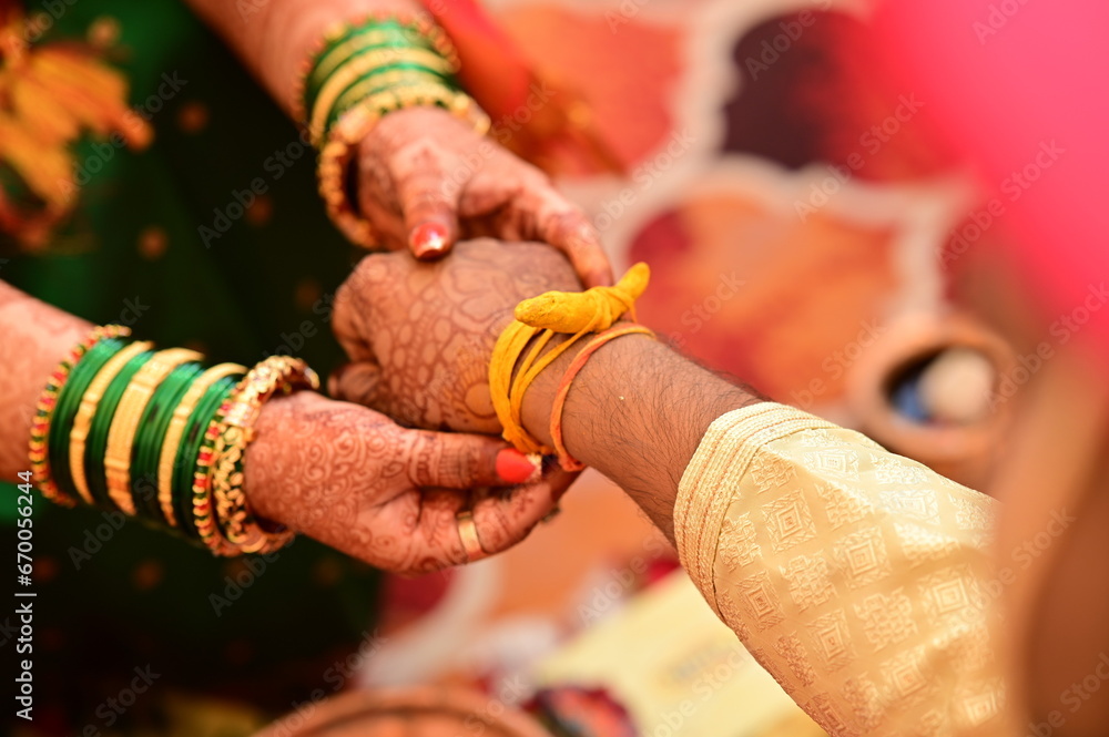 Indian groom Tie a Turmeric Thread on hand of bride. Hands of bride and ...