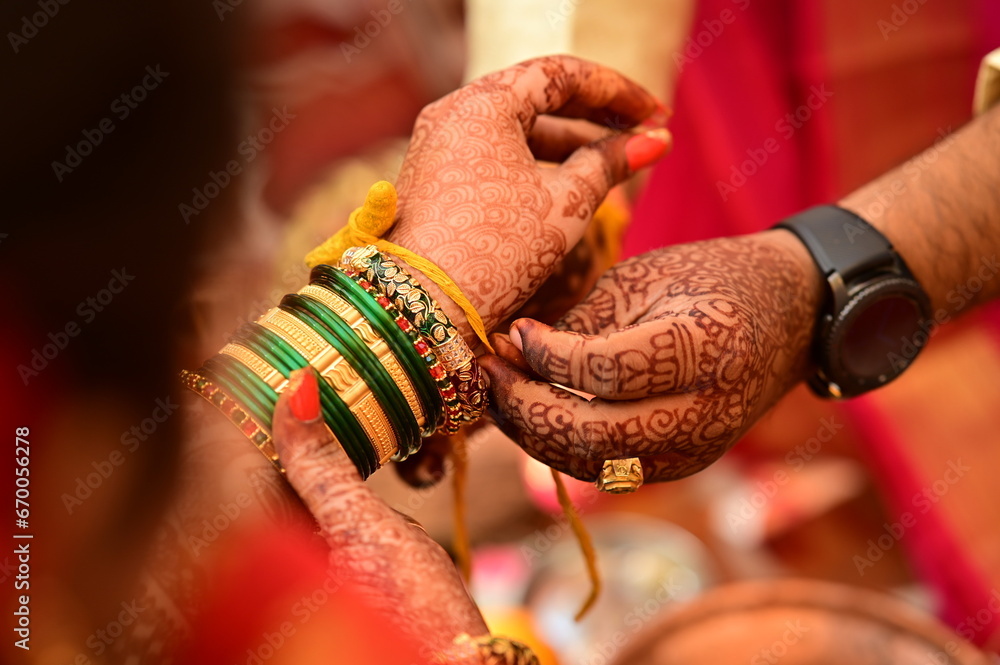 Indian bride Tie a Turmeric Thread on hand of groom. Yellow knot. Hands ...