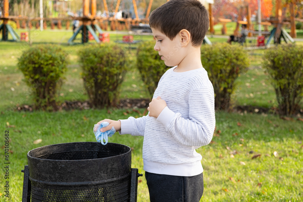 A child throws a plastic bag in the trash. Concept of garbage recycling ...