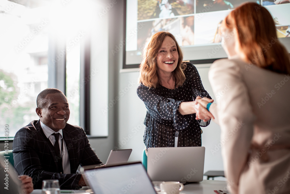 Colleagues share a joyful moment during a conference room presentation ...