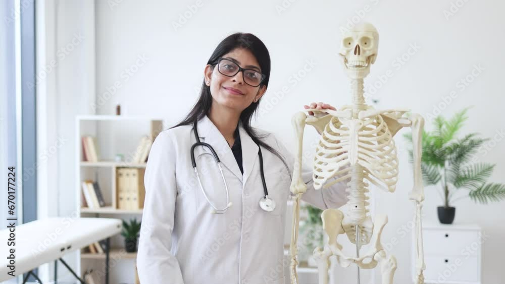 Front view of lady physician wearing hospital gown and goggles standing ...