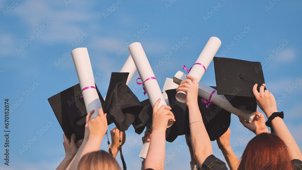 College graduates raise their caps and diplomas upward. Stock Photo ...
