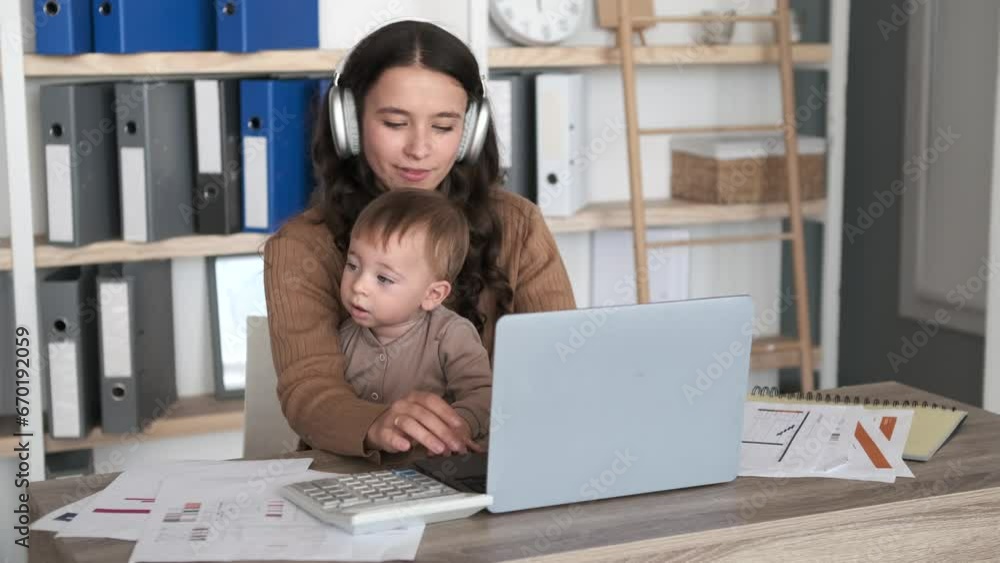 Loving mother multitasks, balancing work duties with the joy of holding ...