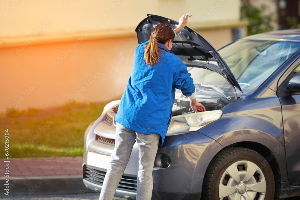 Woman open car hood, steam from the engine compartment. Woman and ...