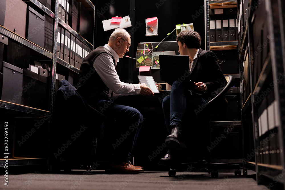 Foto de Elderly police officer examining crime evidence files ...