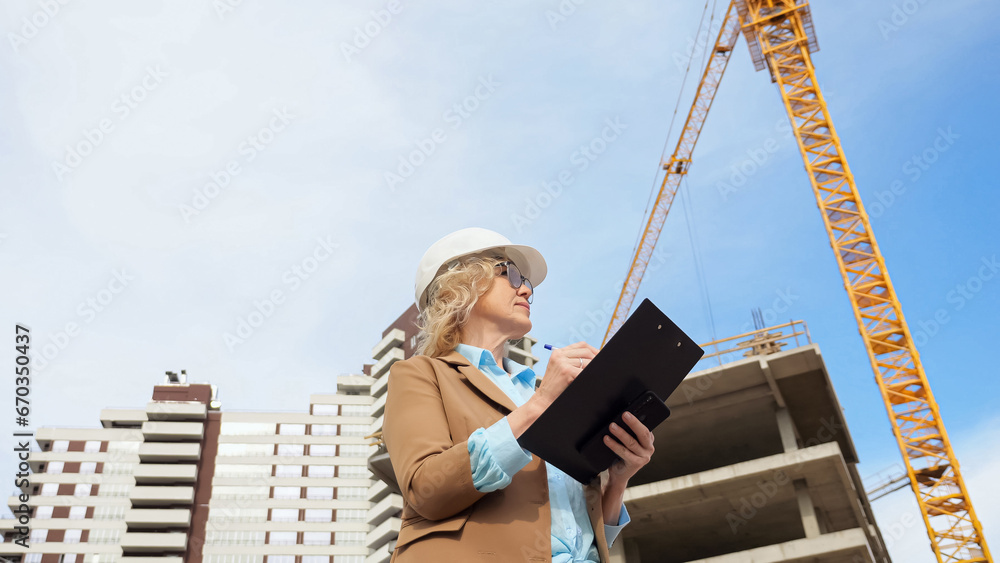 Woman entrepreneur in helmet makes records of work processes at ...