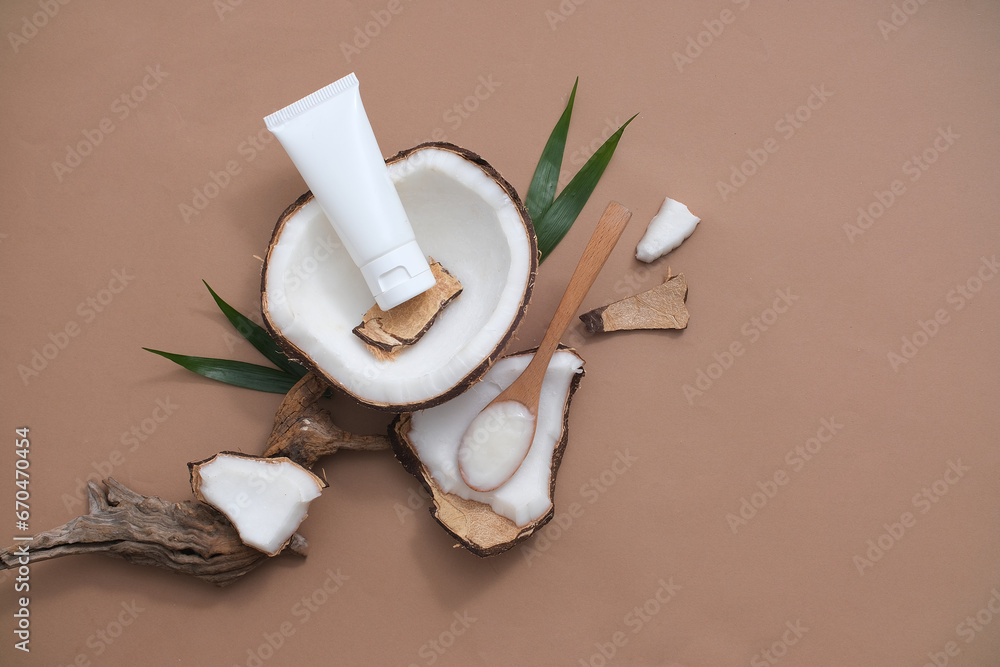 An unlabeled tube of lotion with coconut extract is placed on fresh ...